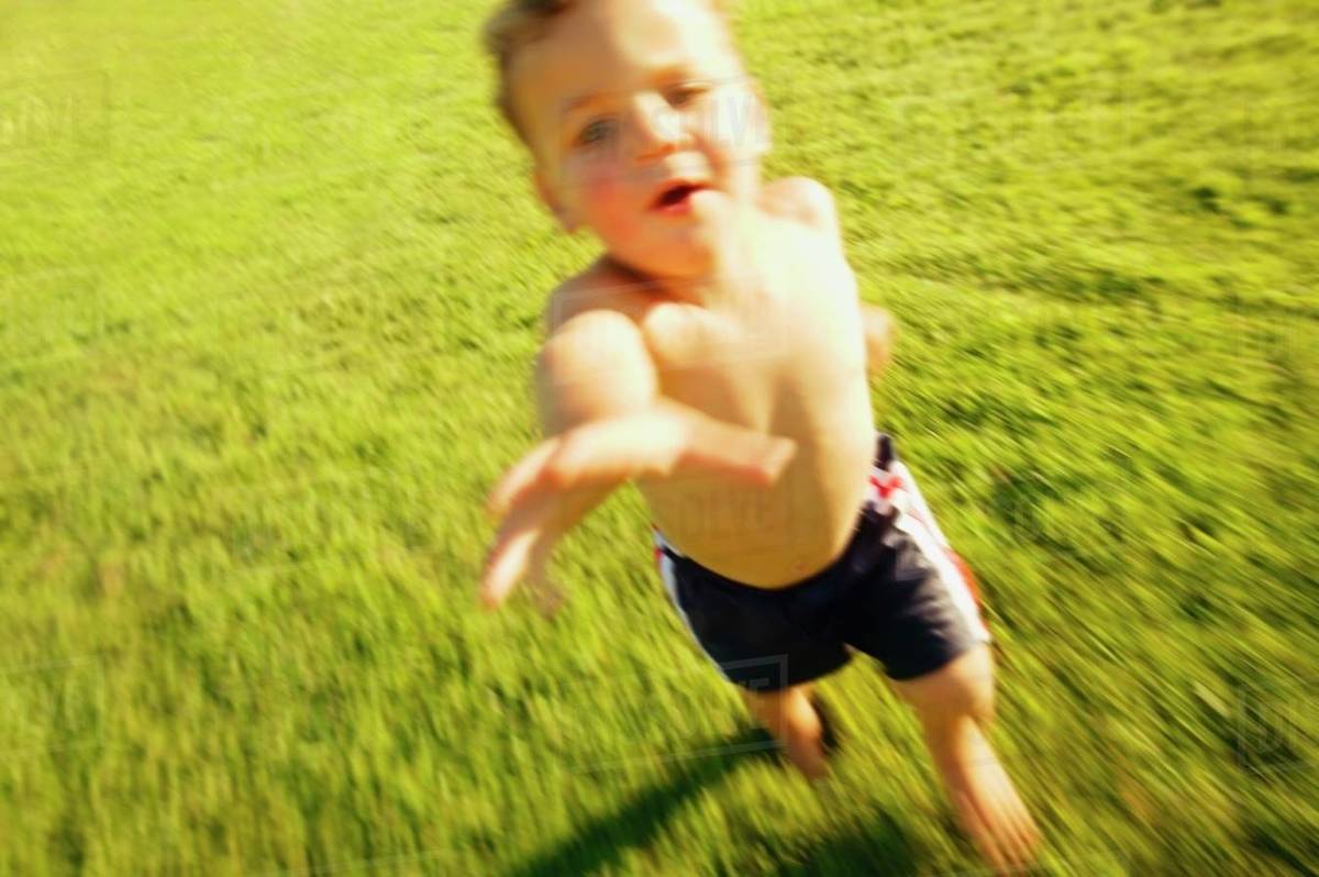 Boy Runs Through Grass - Stock Photo - Dissolve