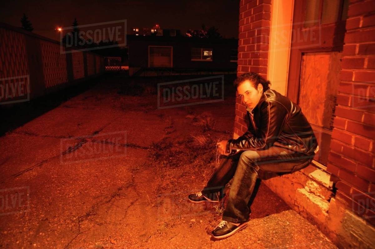 Man Sits Under Street Light - Stock Photo - Dissolve