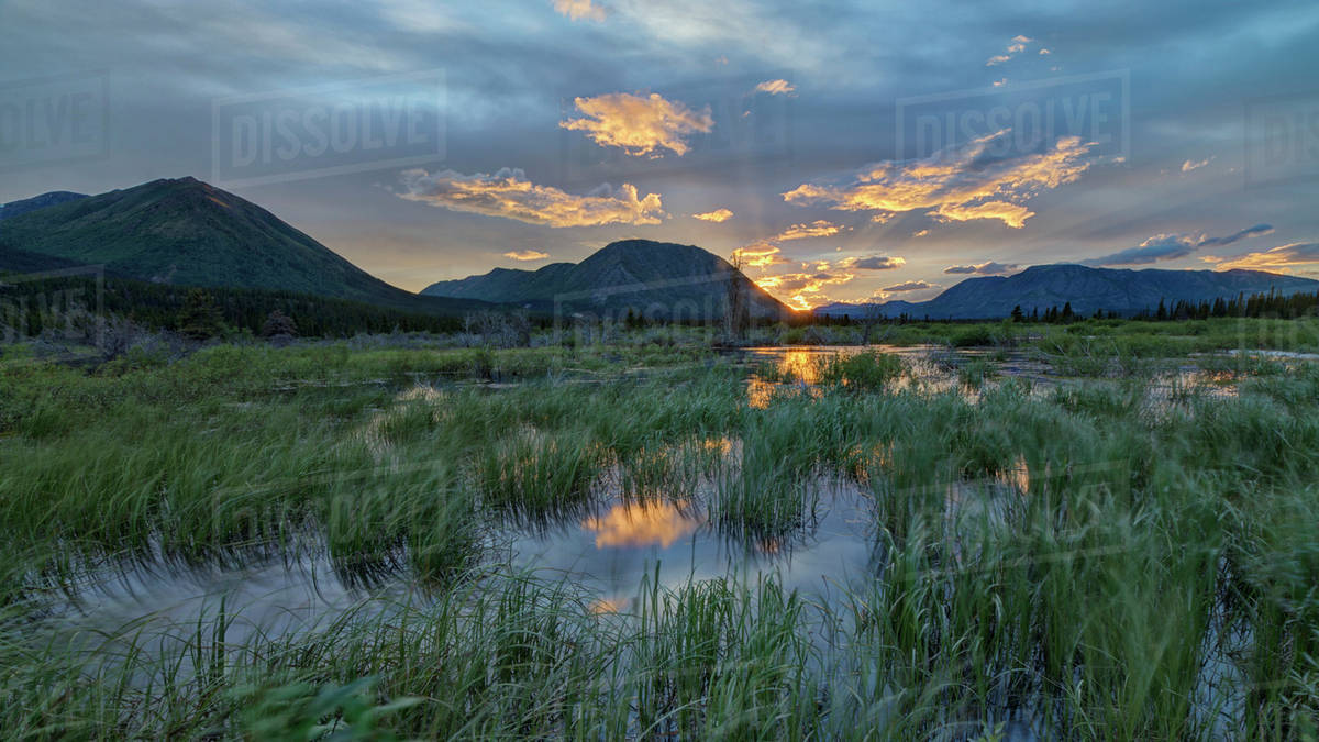 The sun sets and creates bands of light behind Toad Mountain near Annie ...