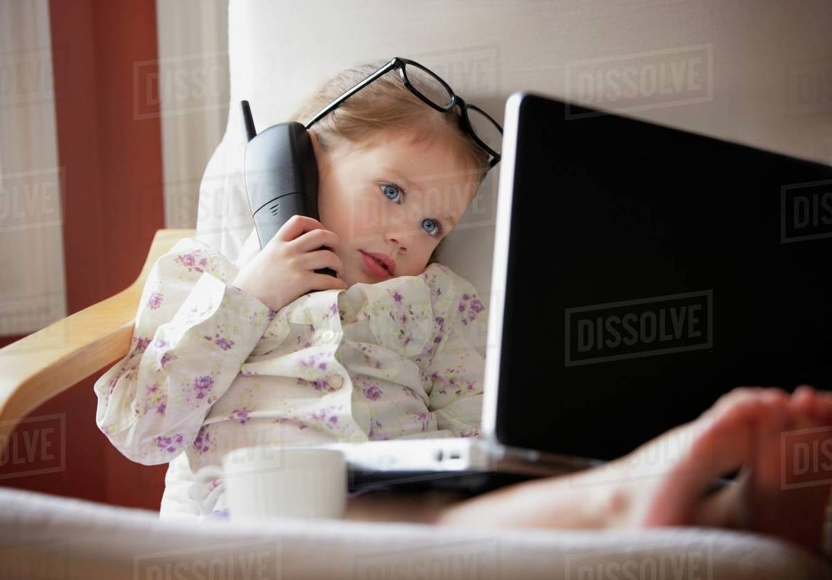 Child Working On Phone And Computer - Royalty-free Stock Photo | Dissolve