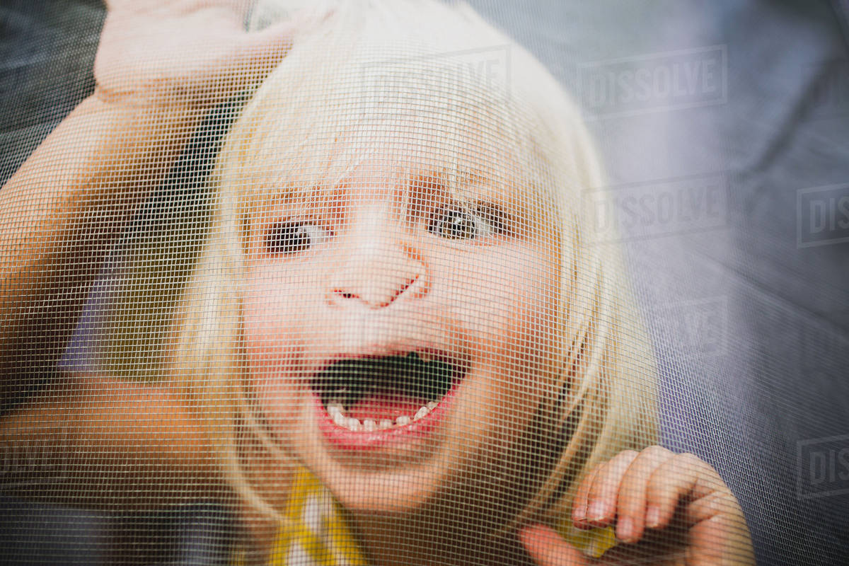 A young girl with a silly expression on her face viewed through a ...