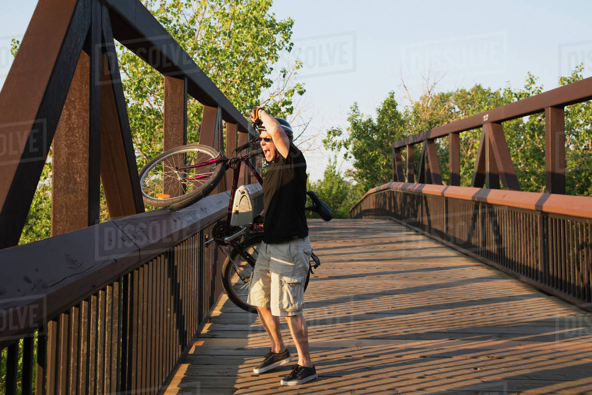 Cyclist throwing electric bicycle off a bridge; Edmonton, Alberta ...
