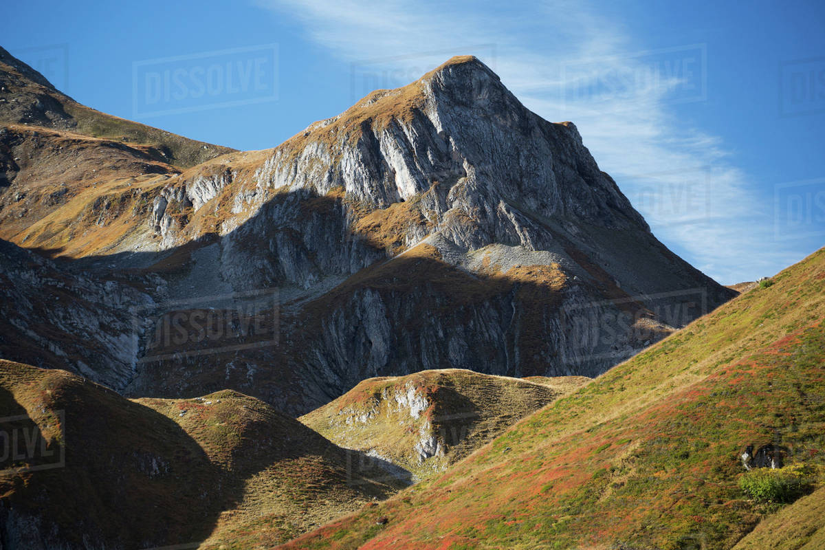 Grass covered slopes in autumn with a mountain peak; Hintertux, Austria ...