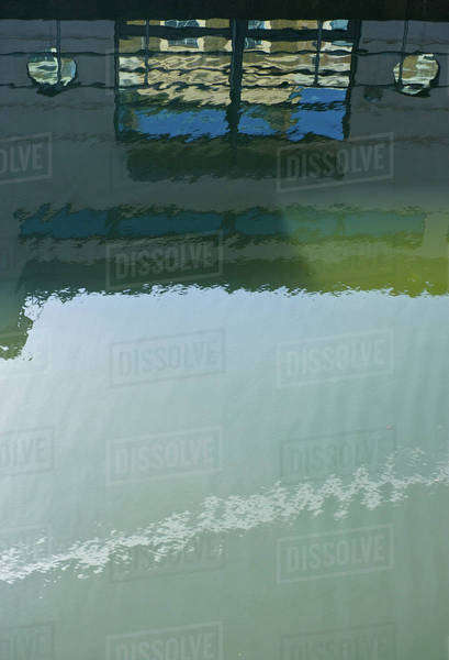 Reflection of a wall, window and blue sky in water; London, England ...