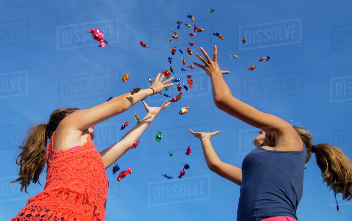 Teenage girls throw sweets in air; United Kingdom - Royalty-free Stock ...