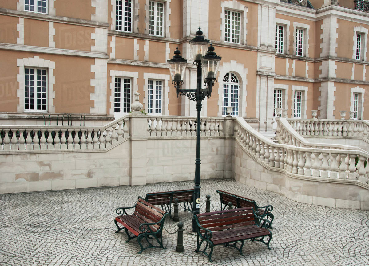 Wooden benches around a lamp post outside of a building;Tokyo japan ...