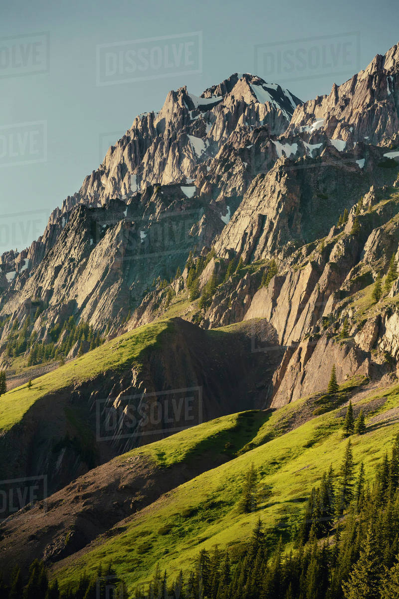 Warm grassy slopes and rocky crags of elpoca mountain;Kananaskis ...