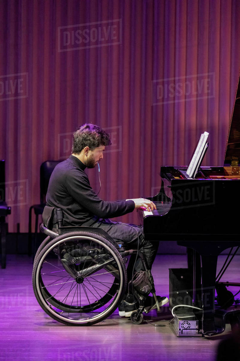 Concert pianist who has a spinal cord injury performing using an ...