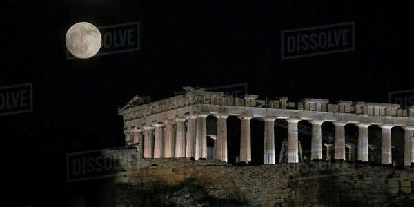 Illuminated Parthenon at night with a full moon over the Acropolis of ...