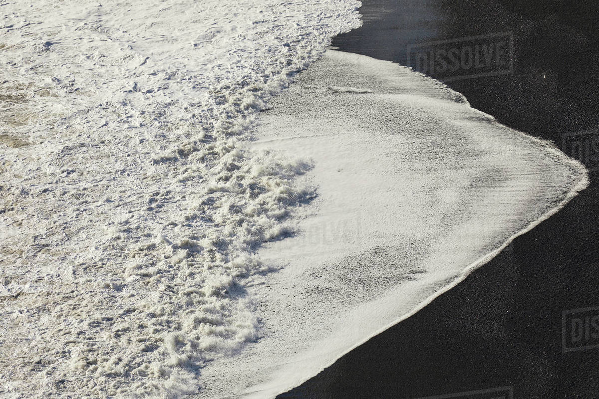 Textures of surf washing onto a black sand beach in Southern Iceland ...