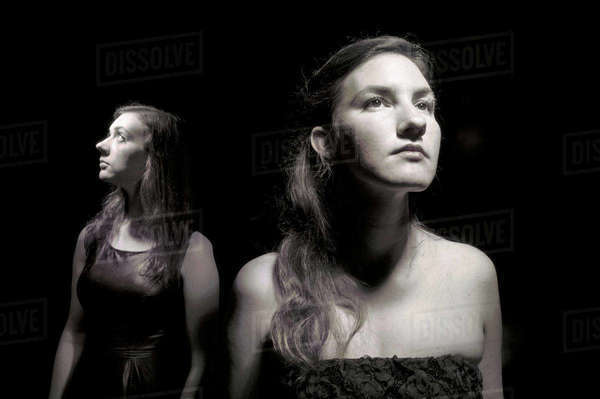 Two young women in formal wear looking upwards against a black ...