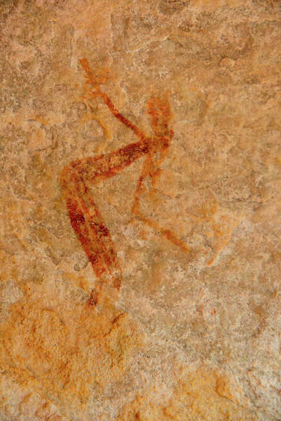Human figure bending and reaching depicted on a rock wall, part of the ...