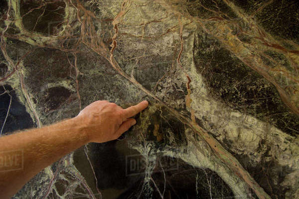 Hand and finger pointing to the designs in a marble countertop; Tampa ...