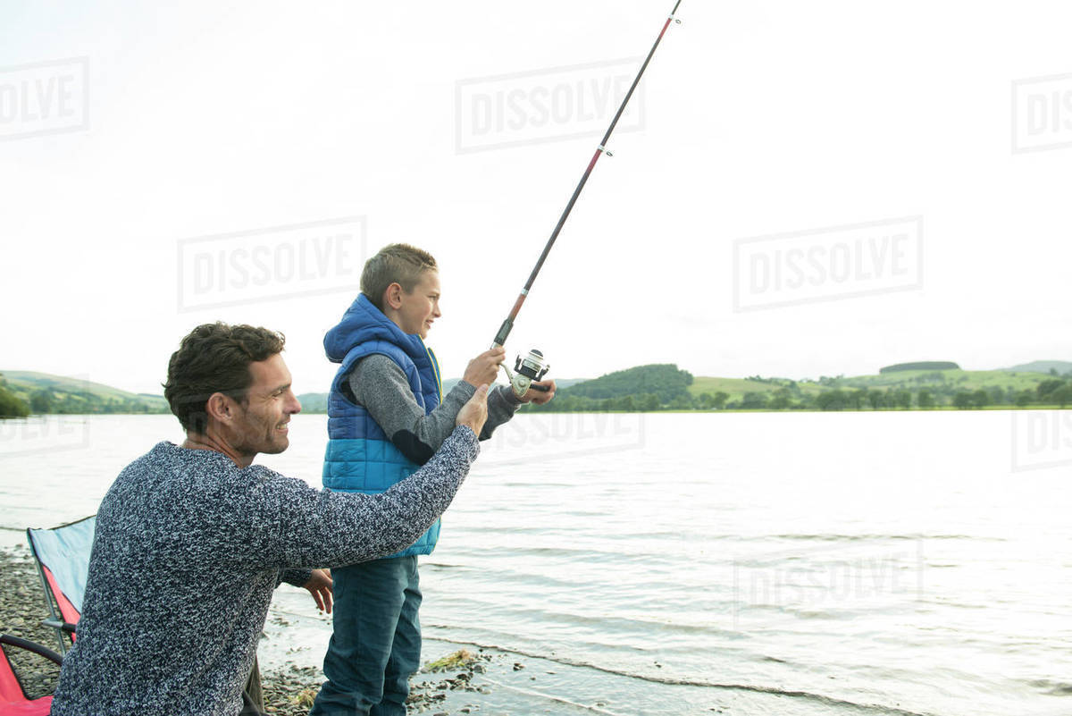 A father and son fishing from the shore of Bala Lake in Wales ...