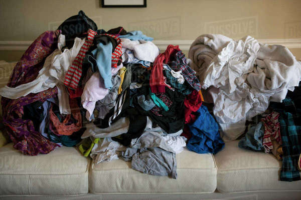 Laundry piles up at home, with a large pile of clean clothes on the ...