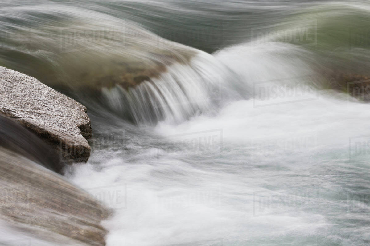 Water flowing over rocks in a waterfall; Whitehorse, Yukon, Canada ...