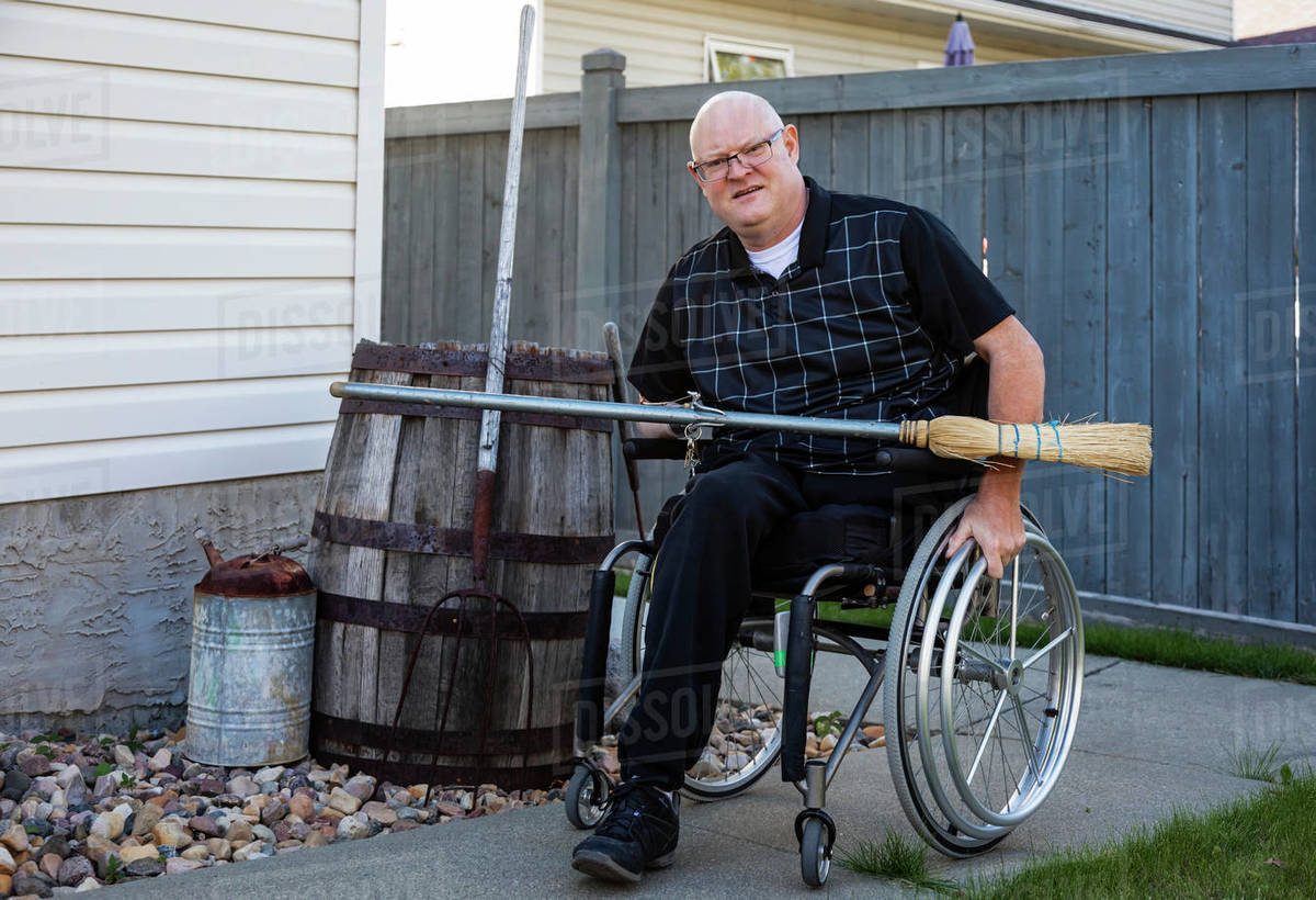 Man with double limb amputations doing yard work in his backyard with a ...