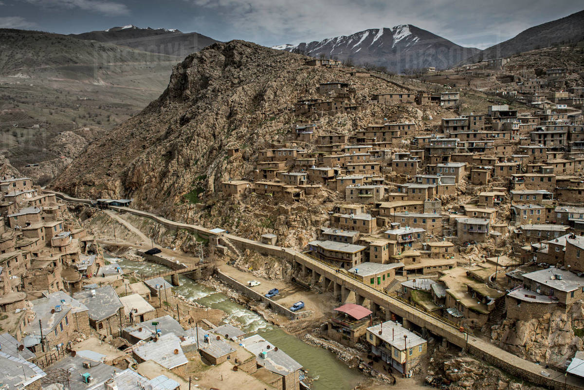 View of a river flowing through a mountain village in the Zagros ...