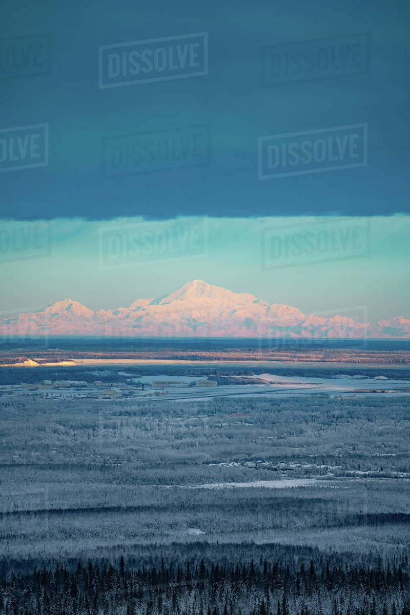 Mt Denali shines in the sun beneath the clouds above the frosty winter ...