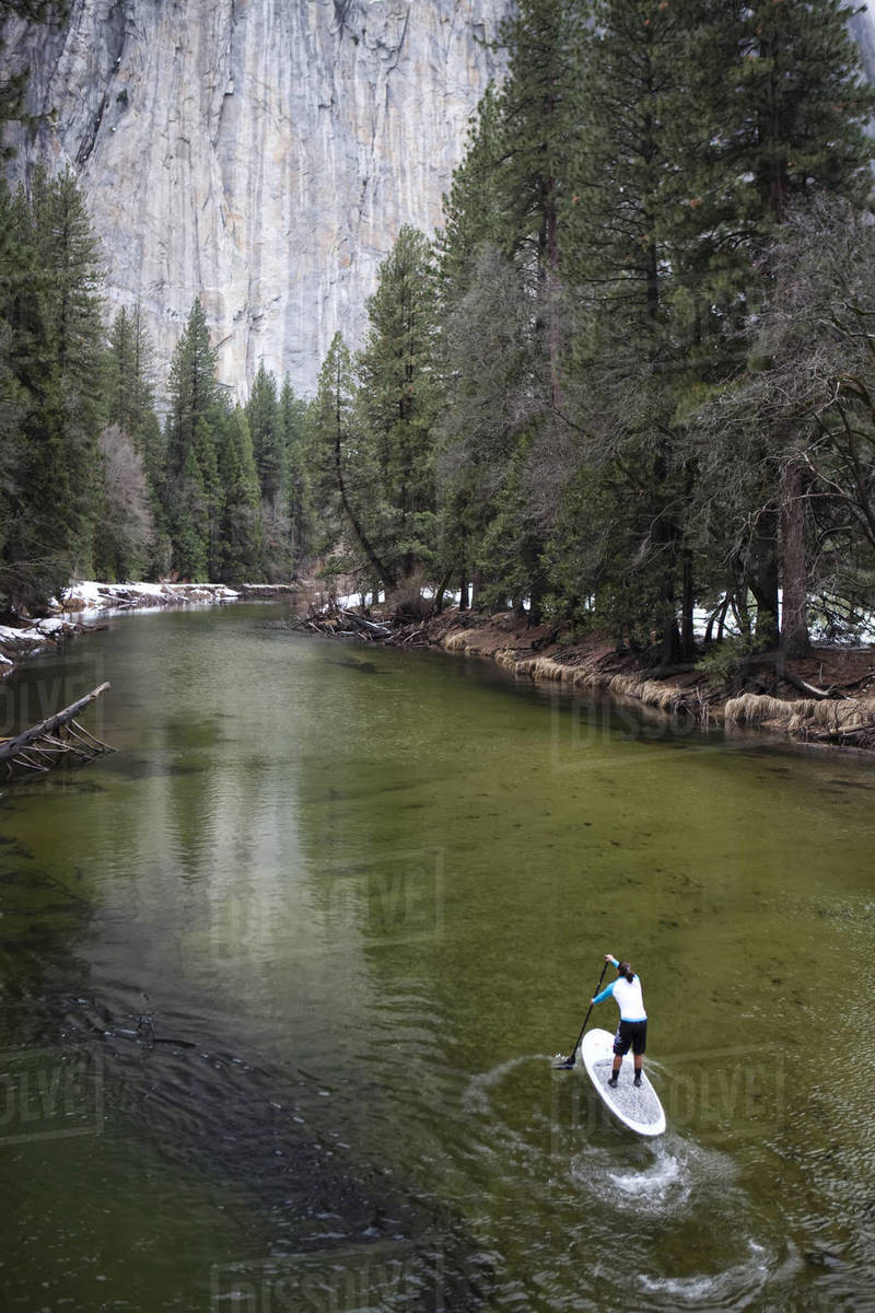 A stand up paddle boarder in the Merced River in winter. - Stock Photo ...