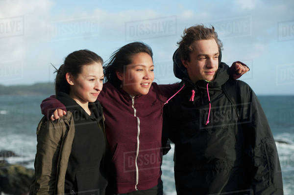 Portrait of three friends at the water's edge;British columbia canada ...