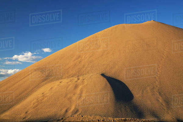 Mound of sand around sunset in a commercial sandpit;Quebec canada ...