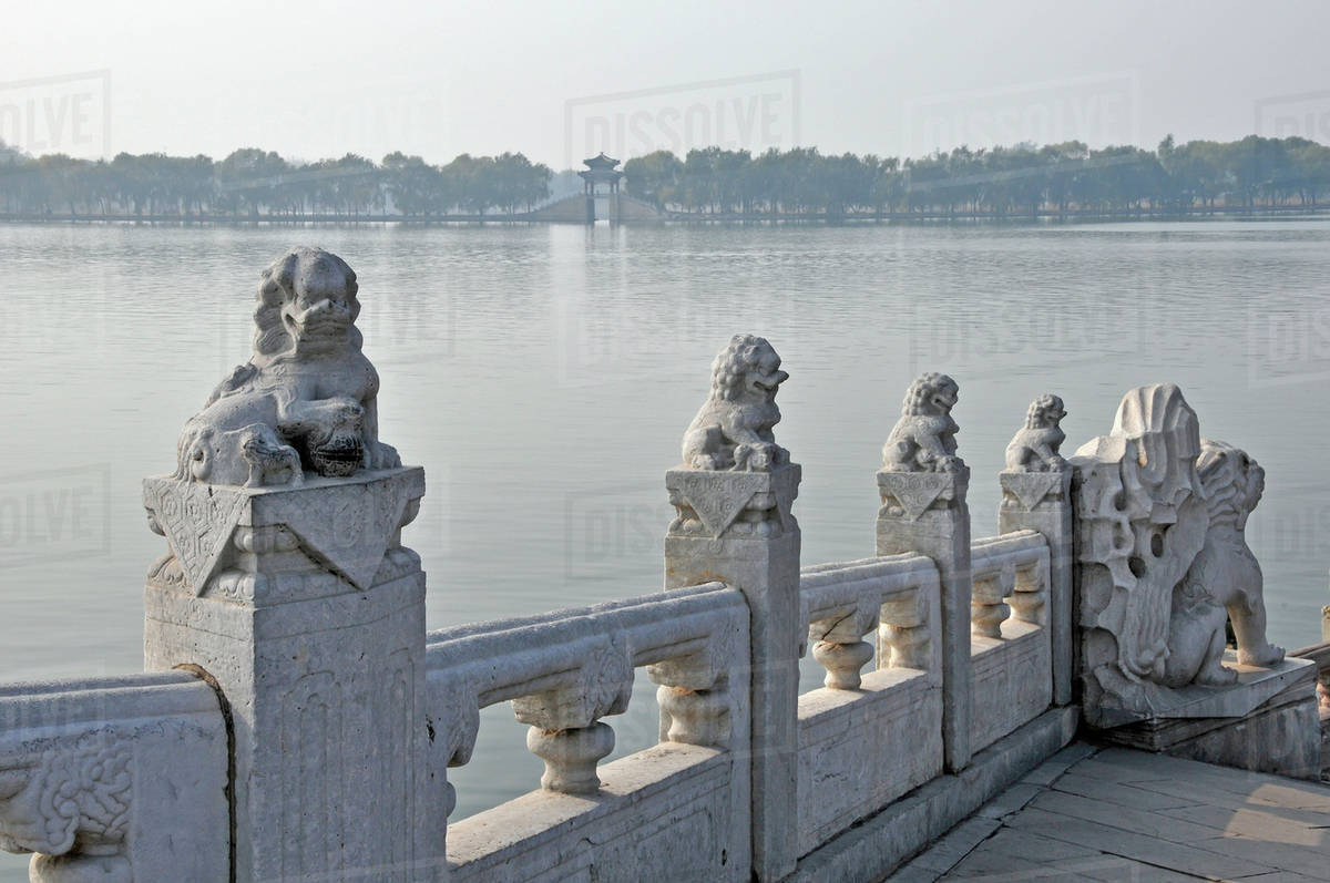 Ornate balusters and sculptures on a railing on the water's edge ...