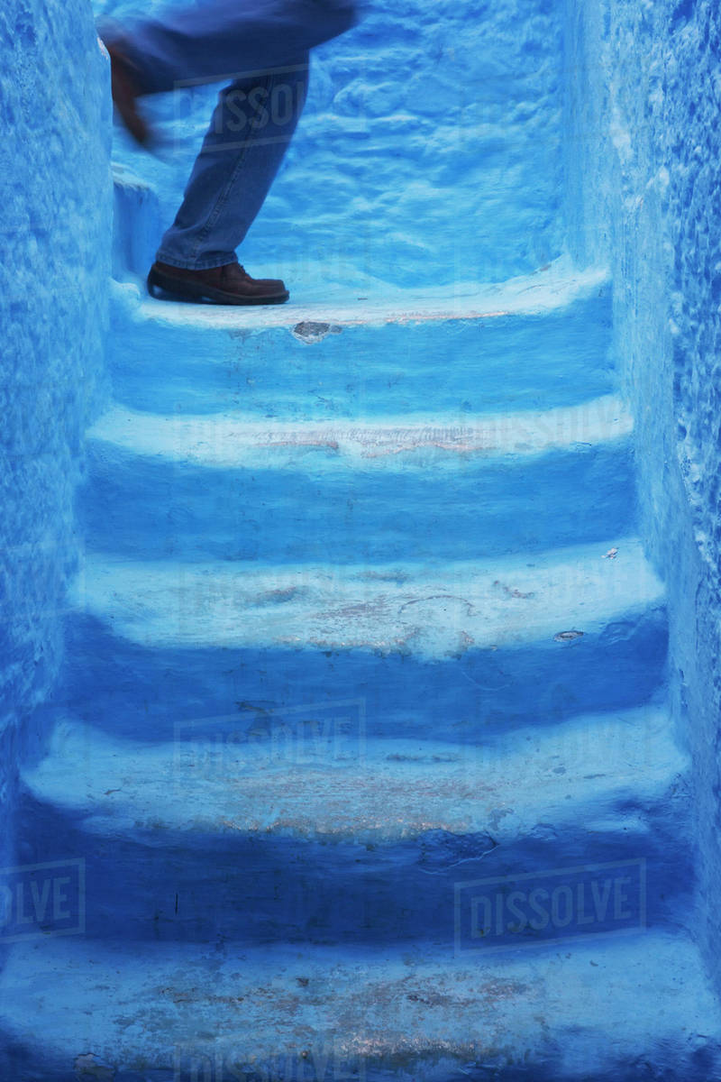 A man walking on blue steps in the medina;Chefchaouen morocco - Stock ...