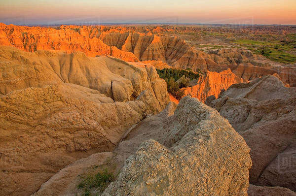 The setting sun lights up the formations in badlands national park as ...