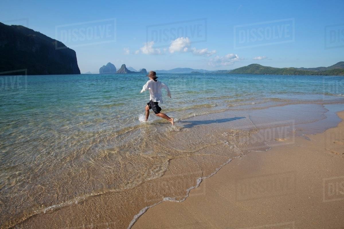 Man Wading Into The Water; Bacuit Archipelago, Palawan, Philippines ...