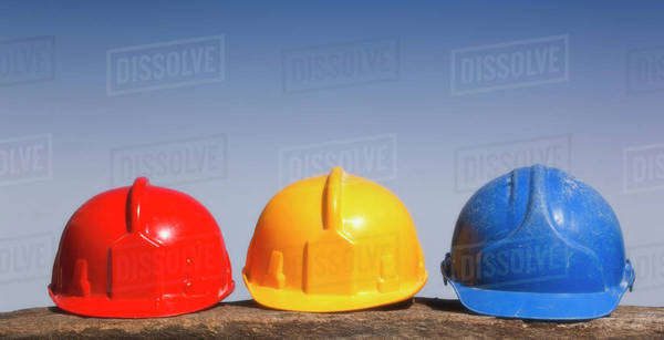 Three Hard Hats In A Row In Primary Colors Red, Yellow And Blue ...