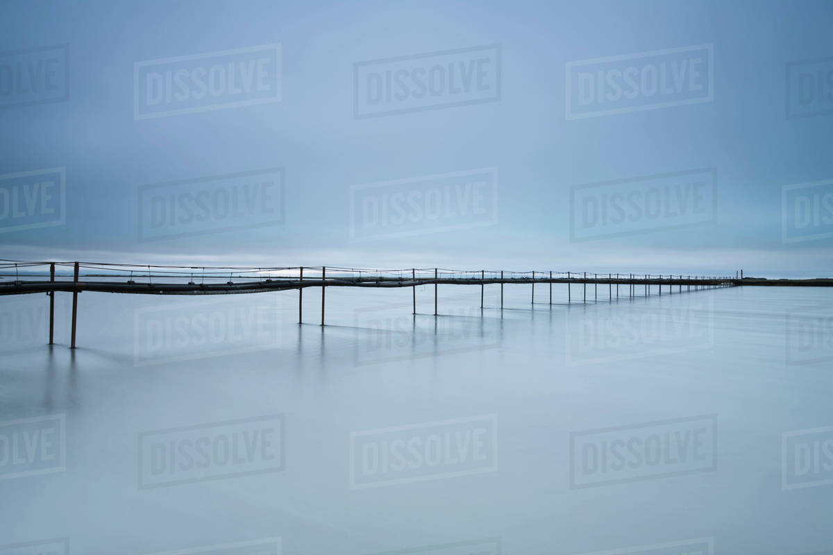 A Long Walking Bridge Over The Water; Iceland - Stock Photo - Dissolve