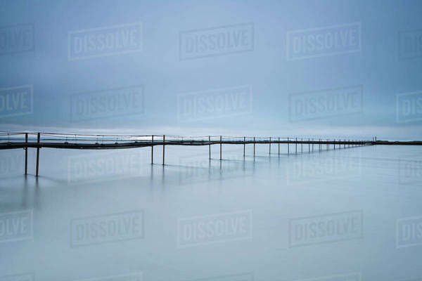 A Long Walking Bridge Over The Water; Iceland - Stock Photo - Dissolve