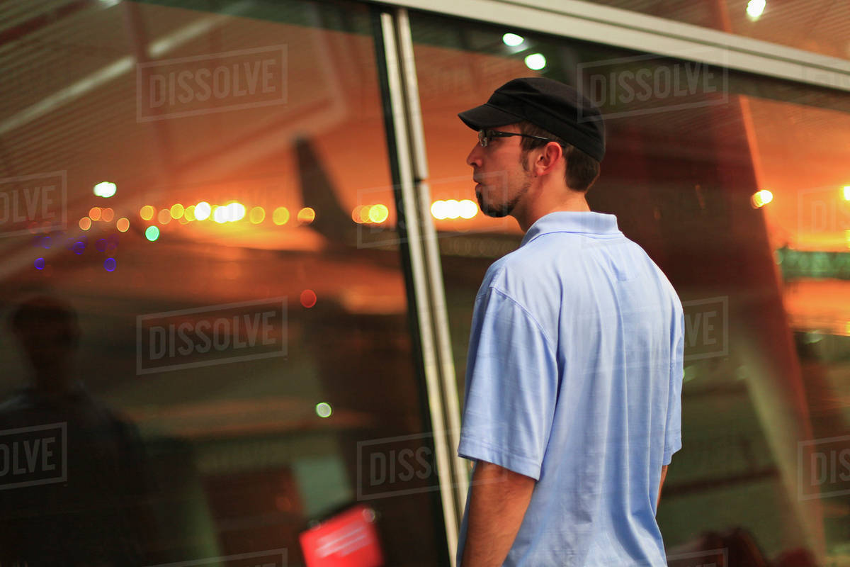 A Young Man Gazing Out A Window At The Beijing Airport; Beijing, China ...