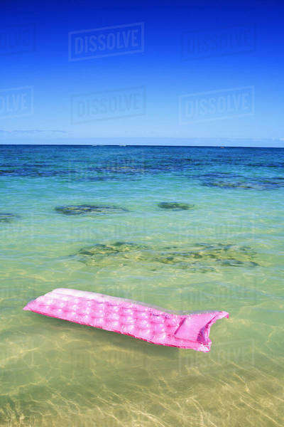 Pink Inflated Raft On Clear Ocean Water. - Stock Photo - Dissolve
