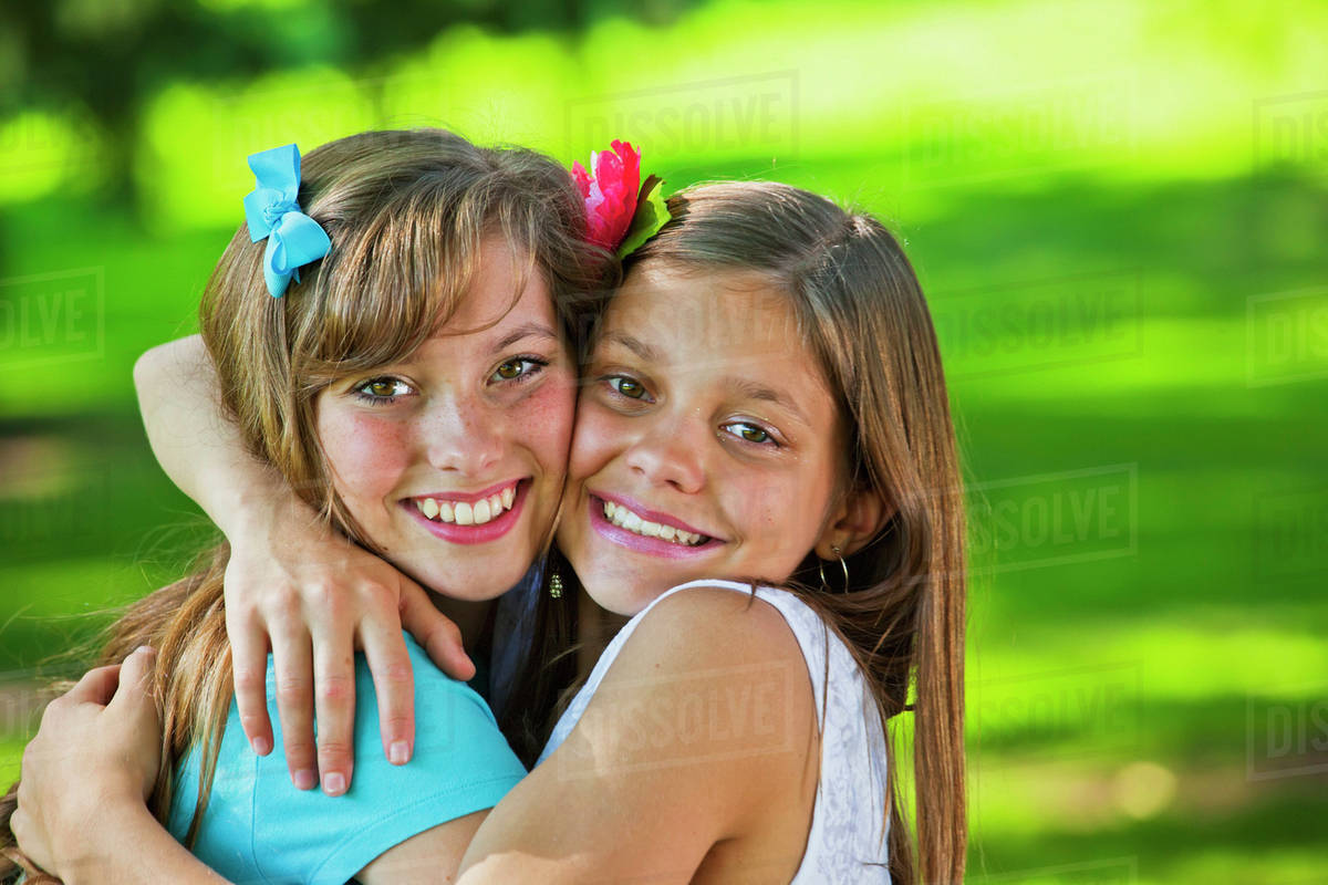 Two Sisters Hugging In A Park; Edmonton, Alberta, Canada - Royalty-free ...