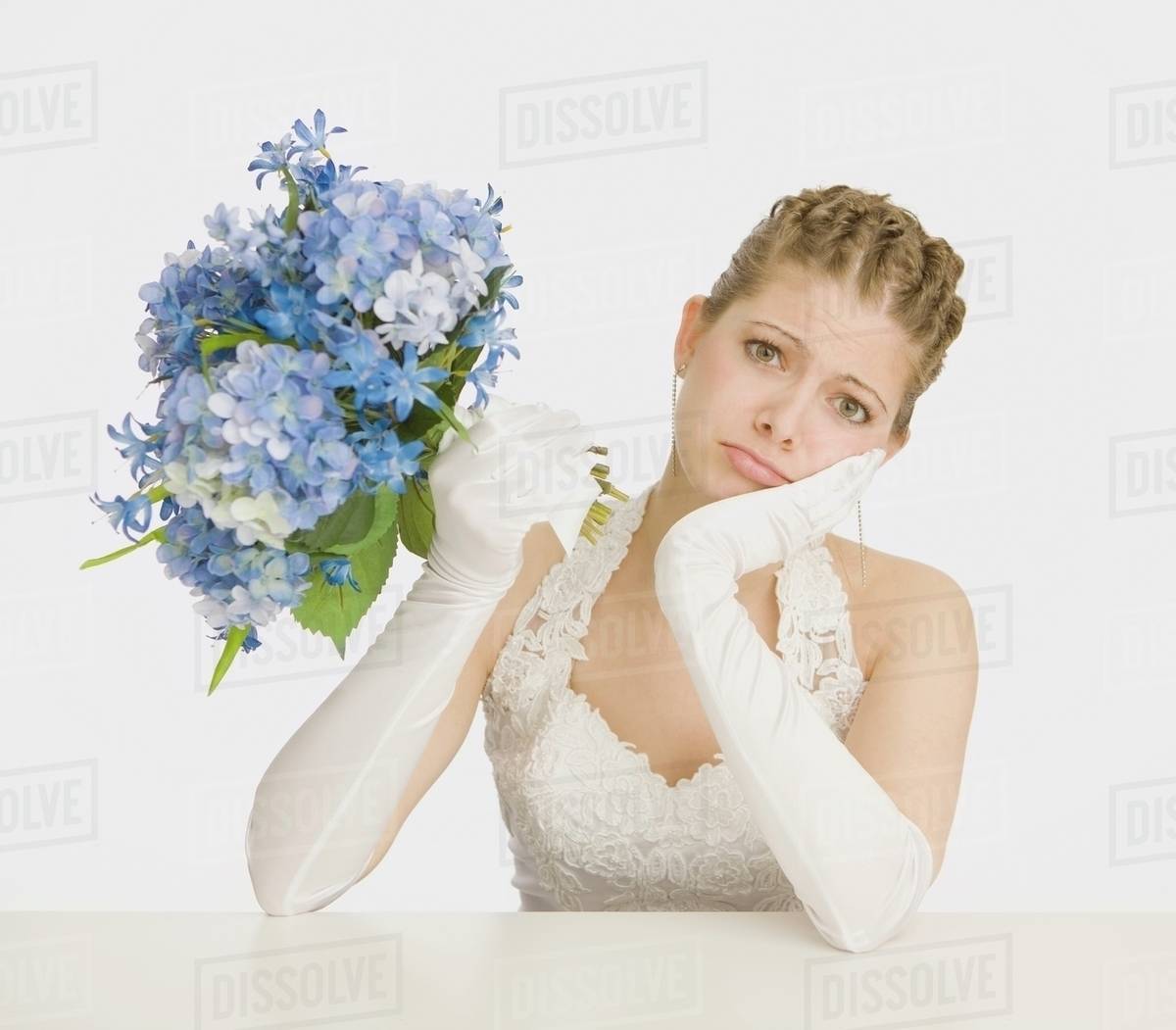 Apprehensive Bride Holding Blue Flowers - Stock Photo - Dissolve