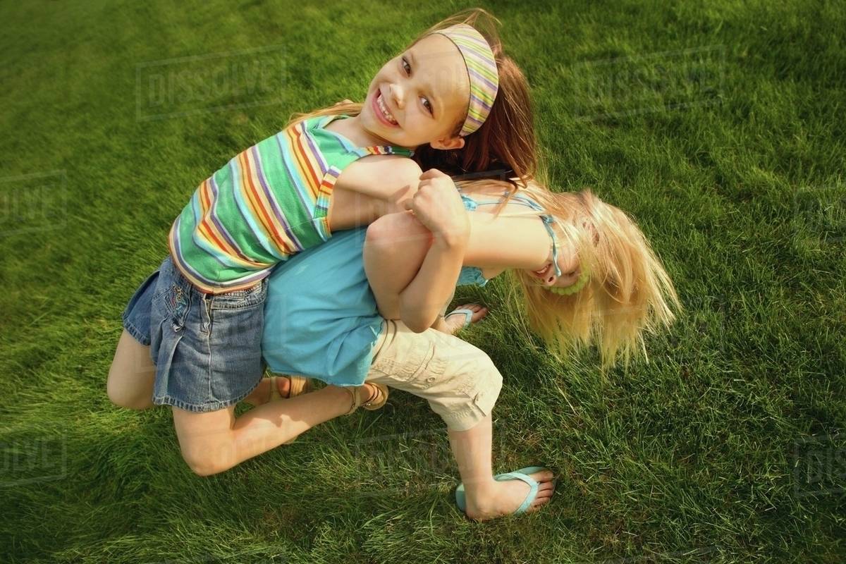 Edmonton, Alberta, Canada; Two Girls Playing Together On The Grass ...