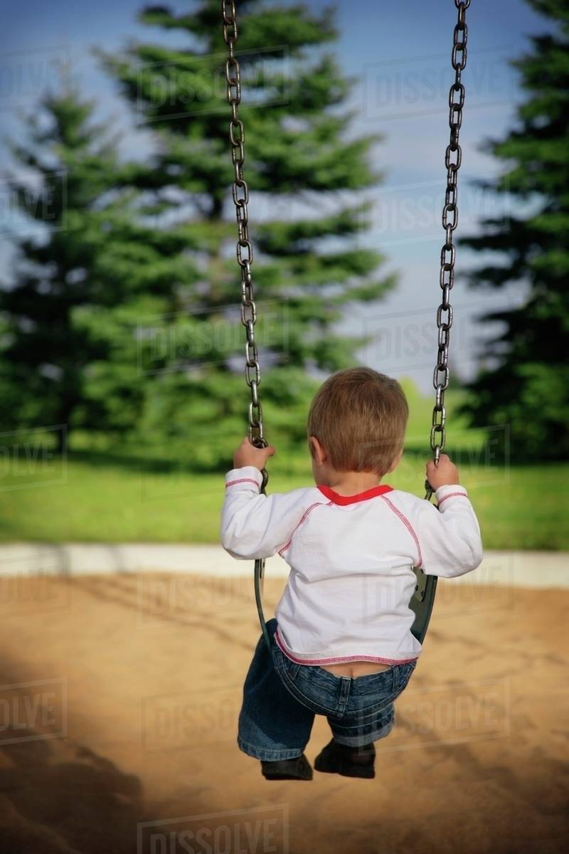 Little Boy Alone On A Swing - Stock Photo - Dissolve