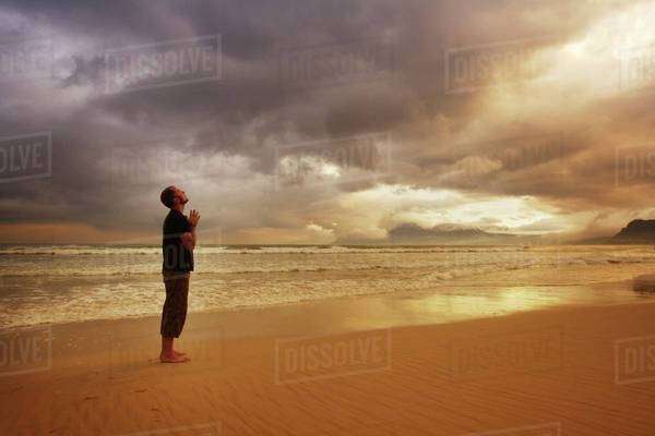 Man Praying On A Beach - Royalty-free Stock Photo | Dissolve