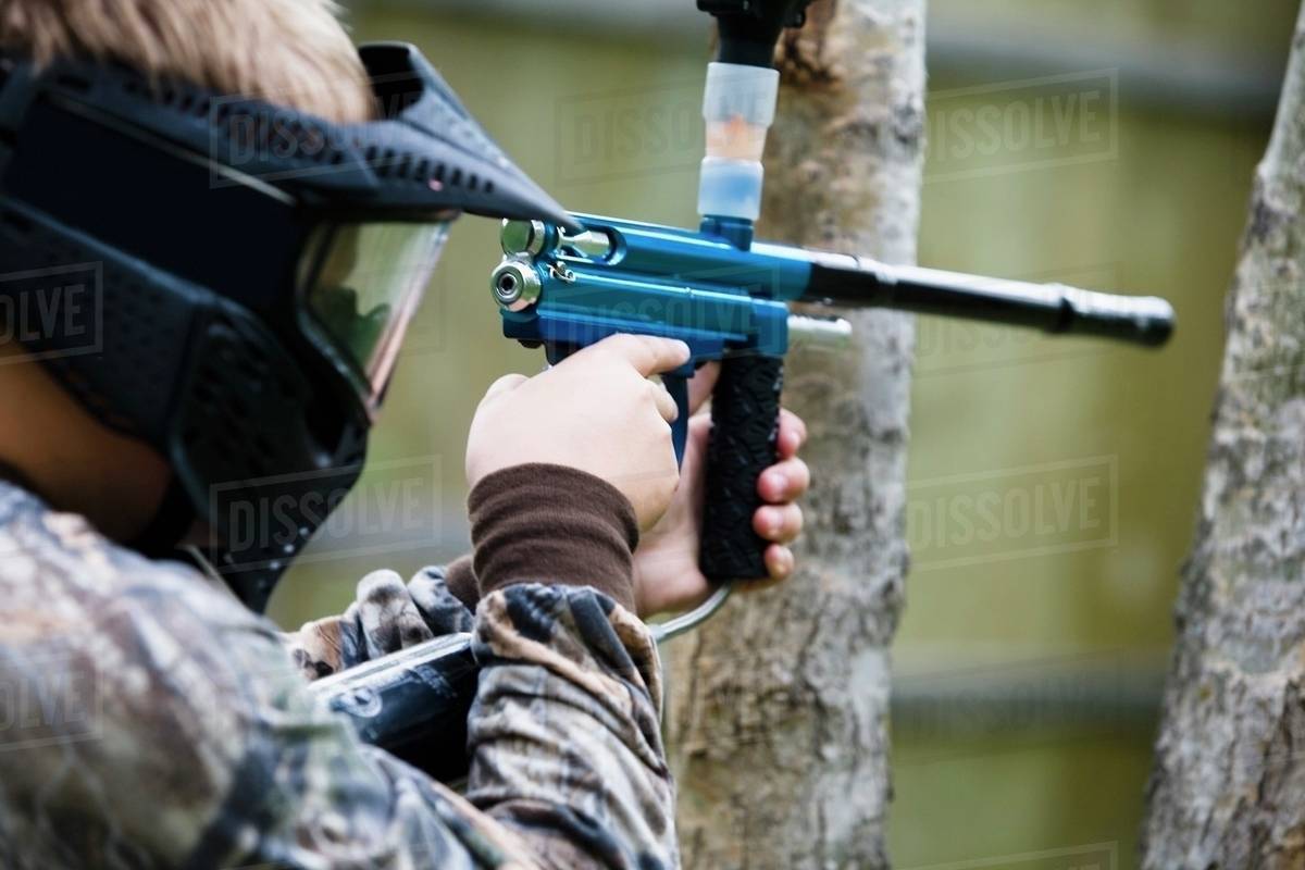 Person Aiming Paintball Gun - Stock Photo - Dissolve