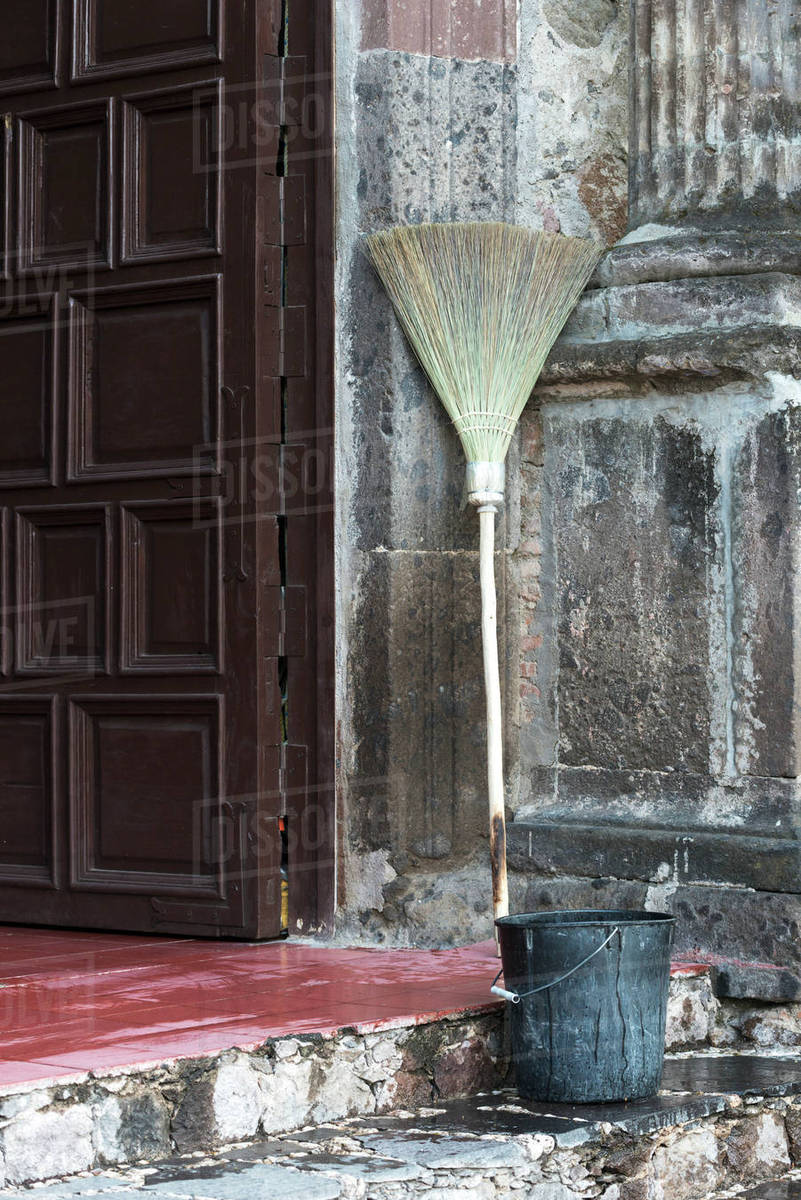 A Broom And Pail Sitting On A Concrete Step In A Doorway; San Miguel De ...