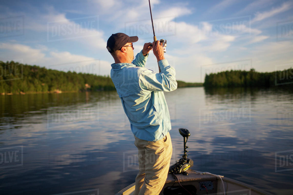 Man with a fish on his line; Ontario, Canada - Stock Photo - Dissolve