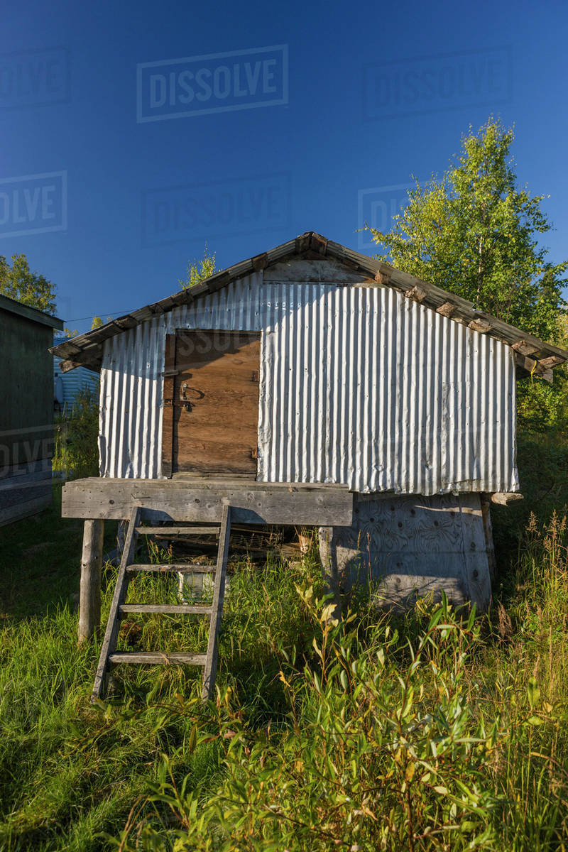 View of the front door of a bear cache with silver metal corrugated ...