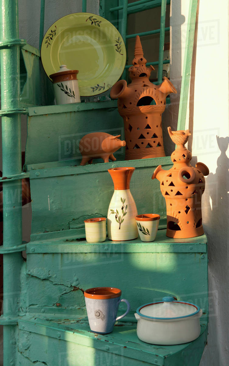 Locally made pottery displayed on a spiral staircase outside a shop ...