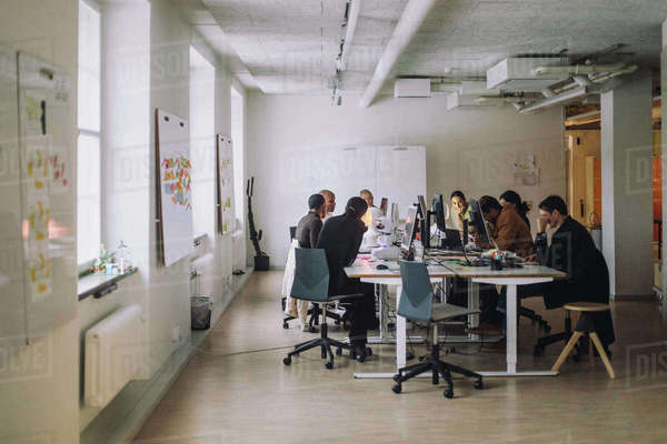 Multiracial PhD students with professors sitting at desk in innovation ...