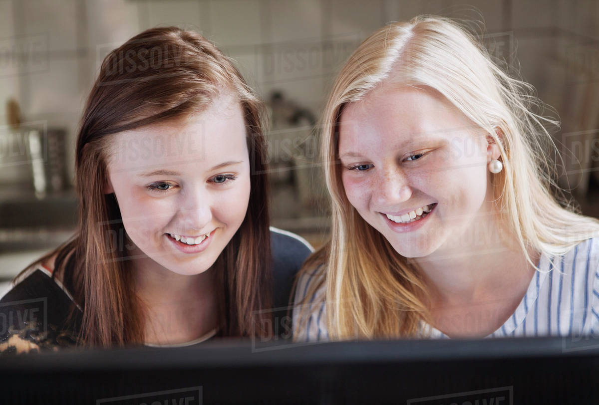 Two happy friends smiling while looking at computer - Royalty-free ...