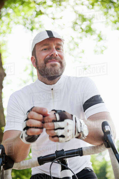 Smiling cyclist with his bicycle - Stock Photo - Dissolve