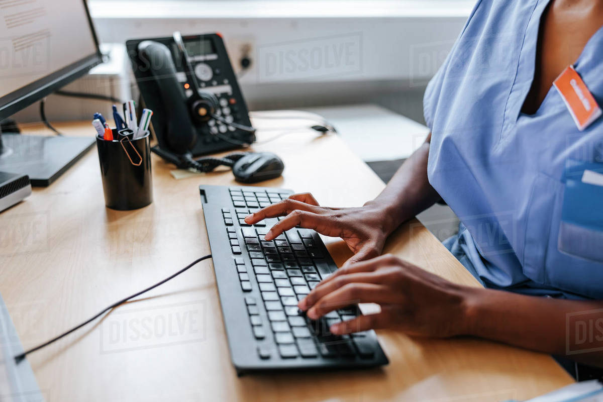 Female doctor typing on computer keyboard at medical clinic - Royalty ...