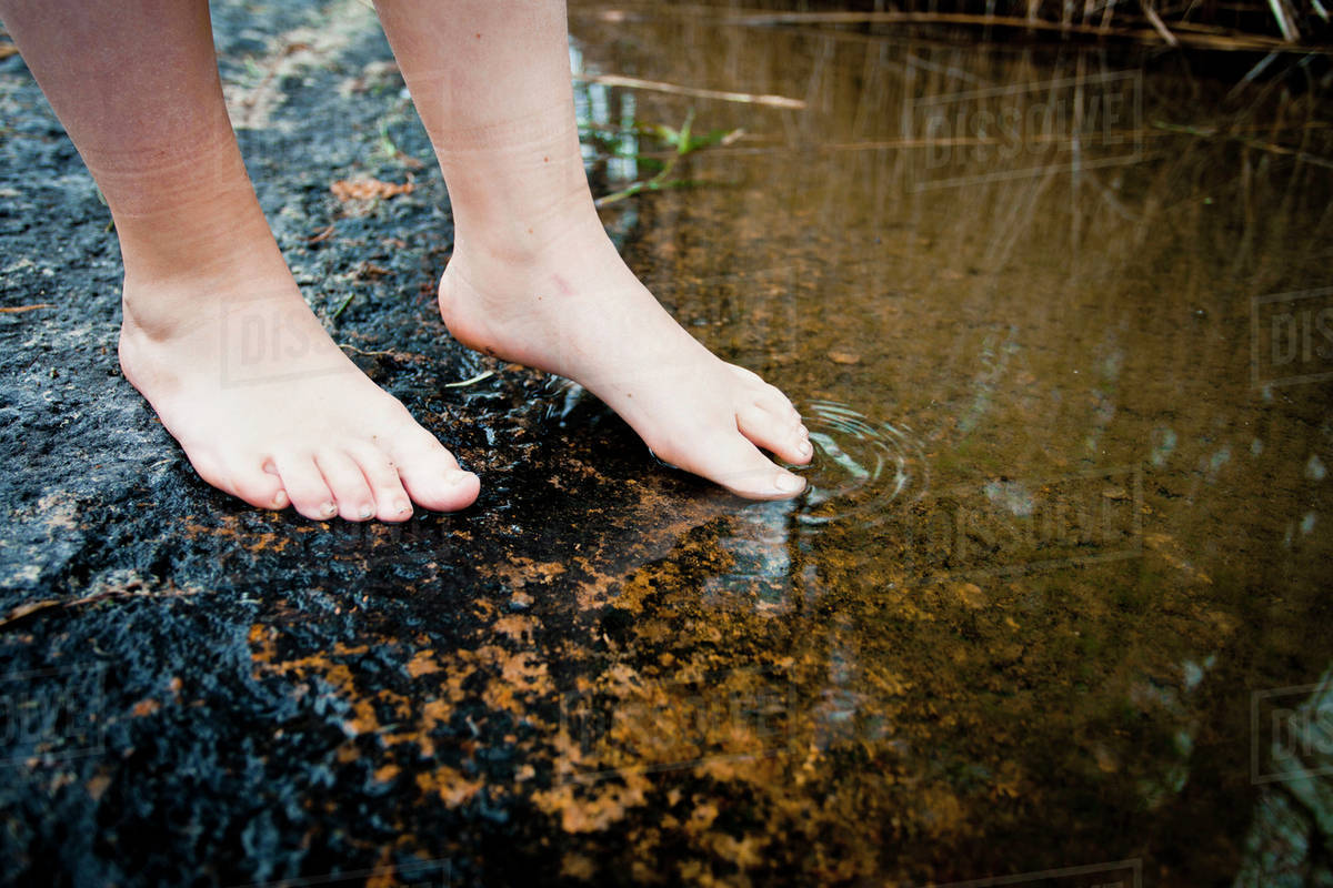 Low section of a person testing the water with toe - Stock Photo - Dissolve